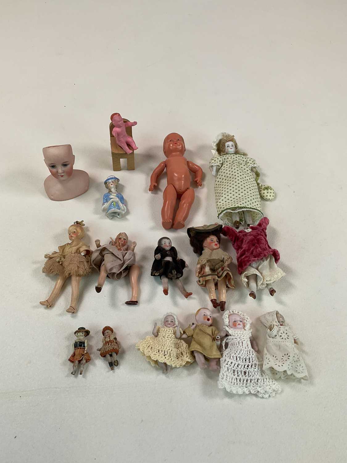 Lot 347 - A collection of miniature dolls including a